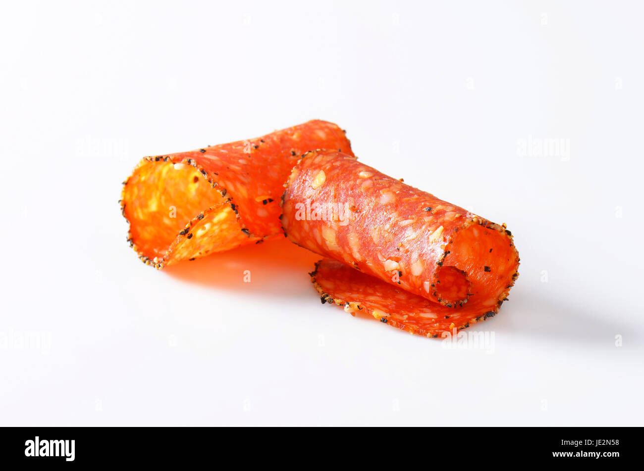 Thin slices of black pepper-coated salami speckled with pieces of Comte ...