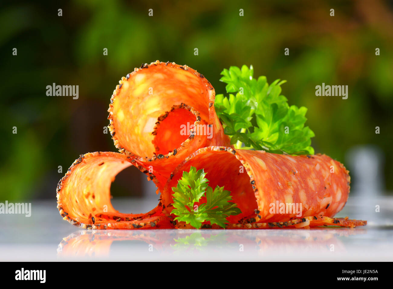 Thin slices of black pepper-coated salami speckled with pieces of Comte ...