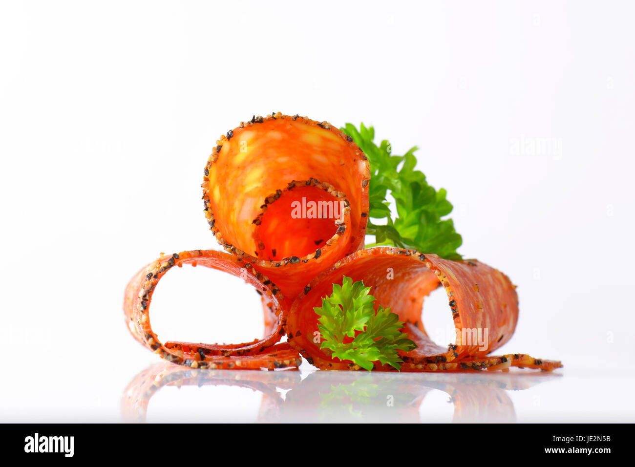 Thin slices of black pepper-coated salami speckled with pieces of Comte ...