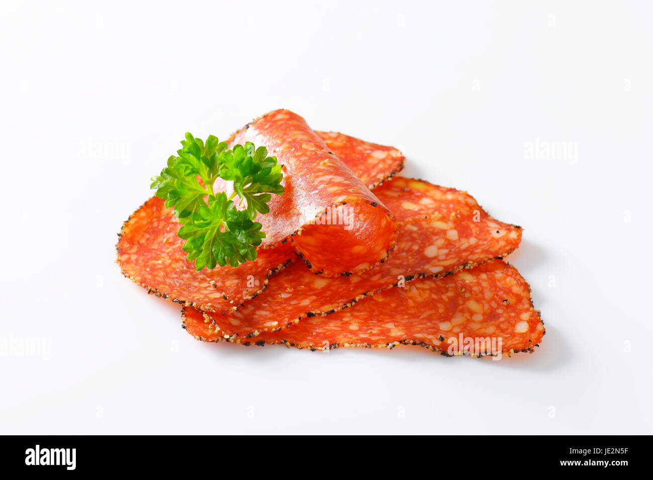 Thin slices of black pepper-coated salami speckled with pieces of Comte ...