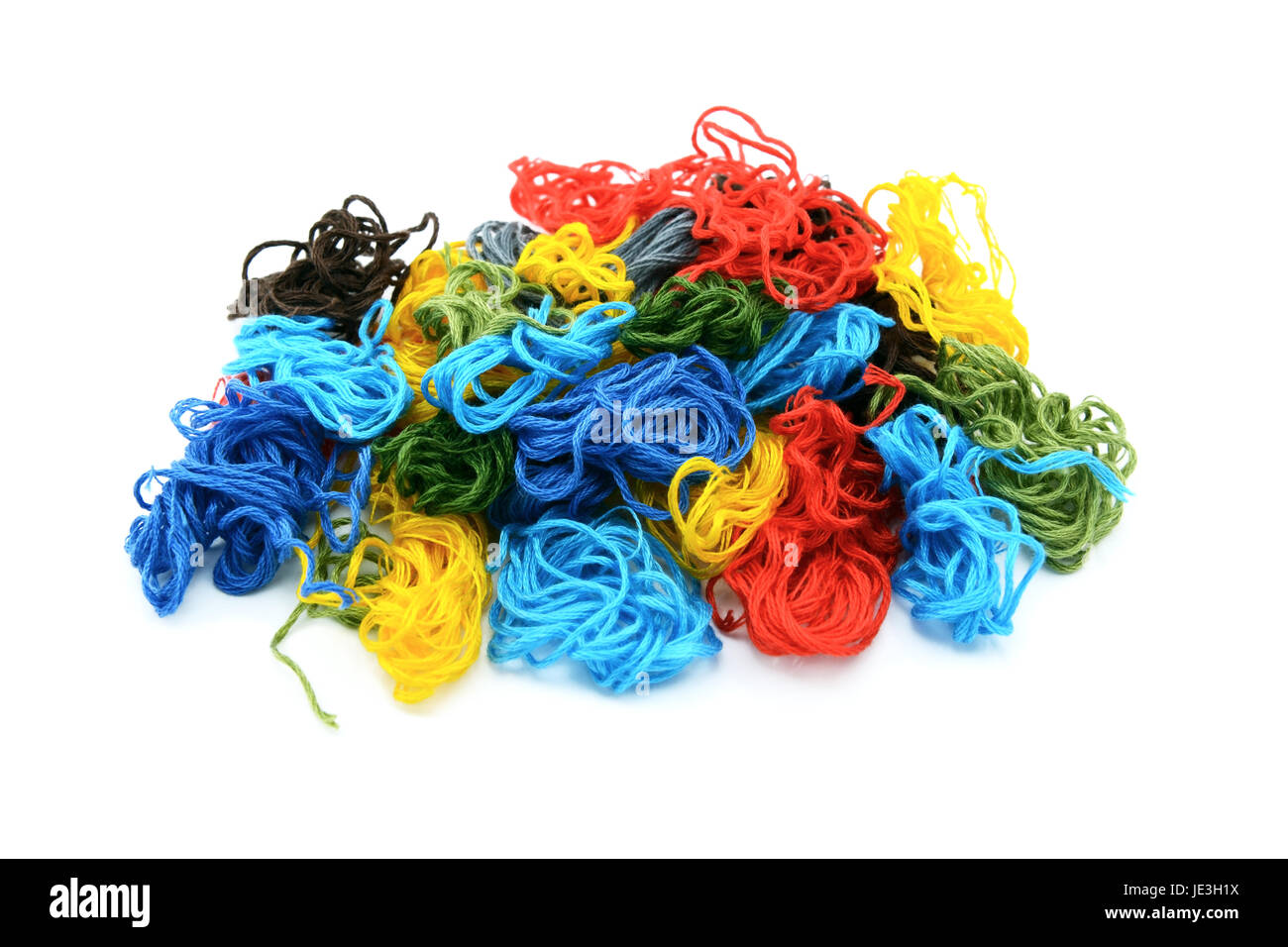 Assorted colourful embroidery threads in a heap, isolated on a white ...