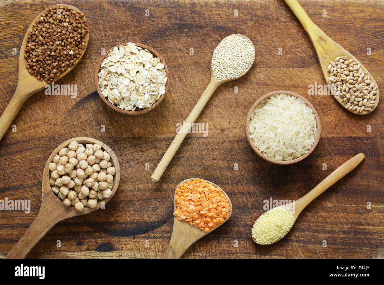 Different types of cereals in wooden spoons - buckwheat, chickpeas ...