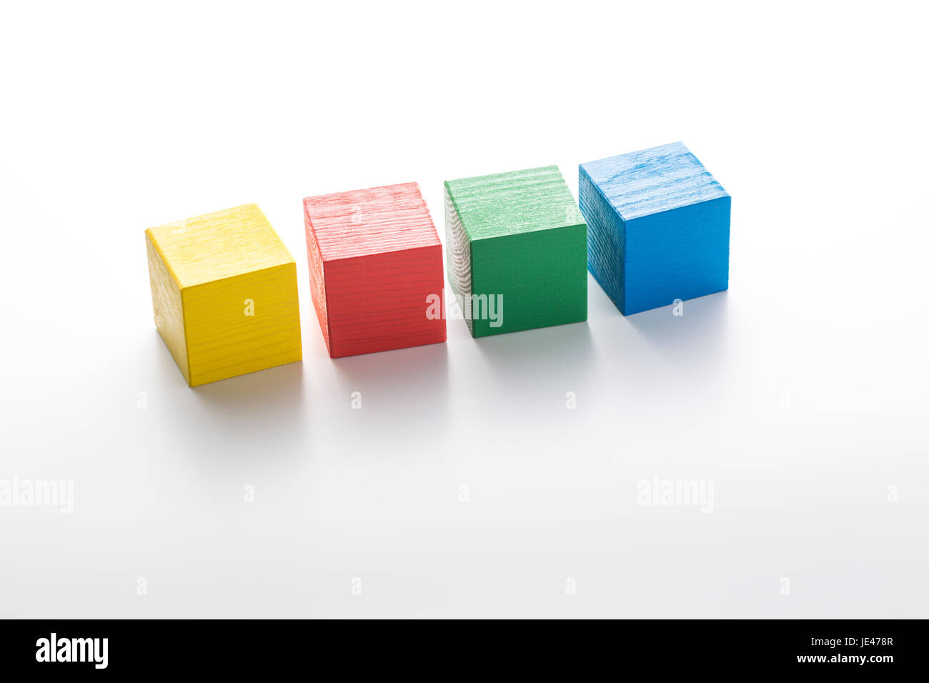 Yellow, red, green and blue wooden cubes isolated on white background ...
