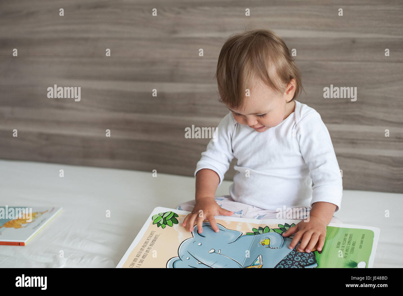One year old infant looking at at a colorful children´s book Stock ...