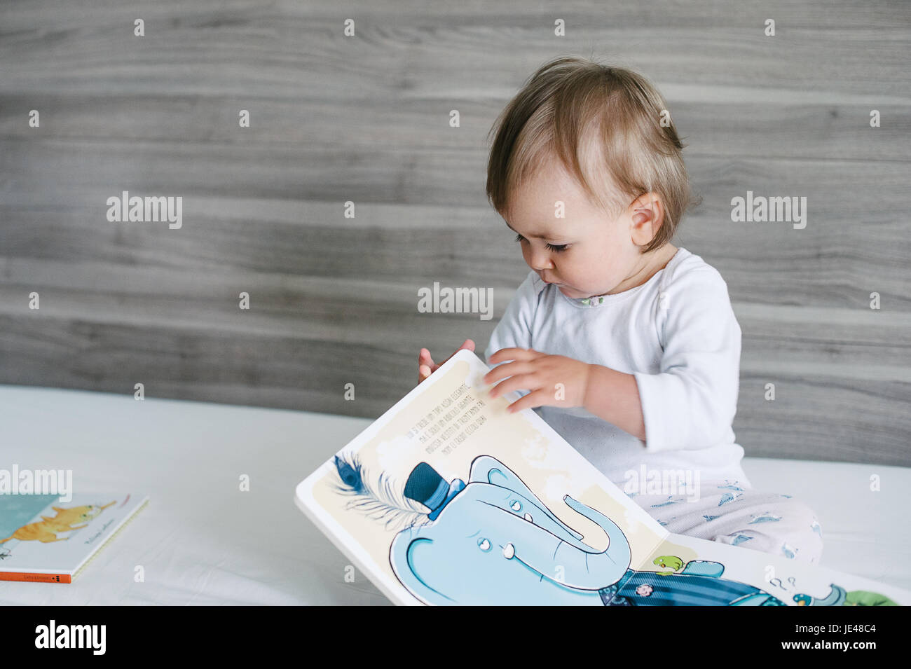 One year old infant looking at at a colorful children´s book Stock ...