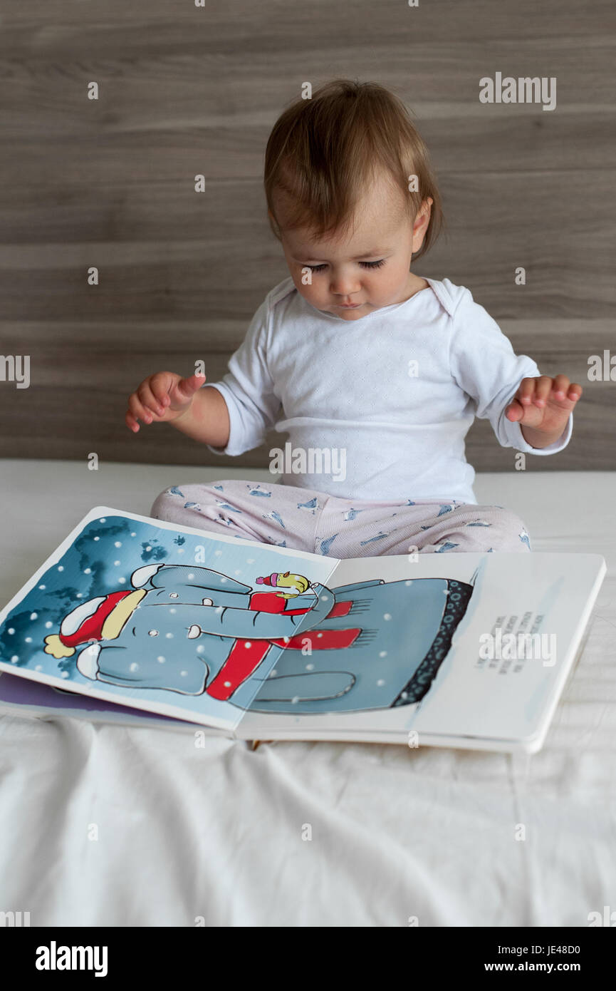 One year old infant looking at at a colorful children´s book Stock ...
