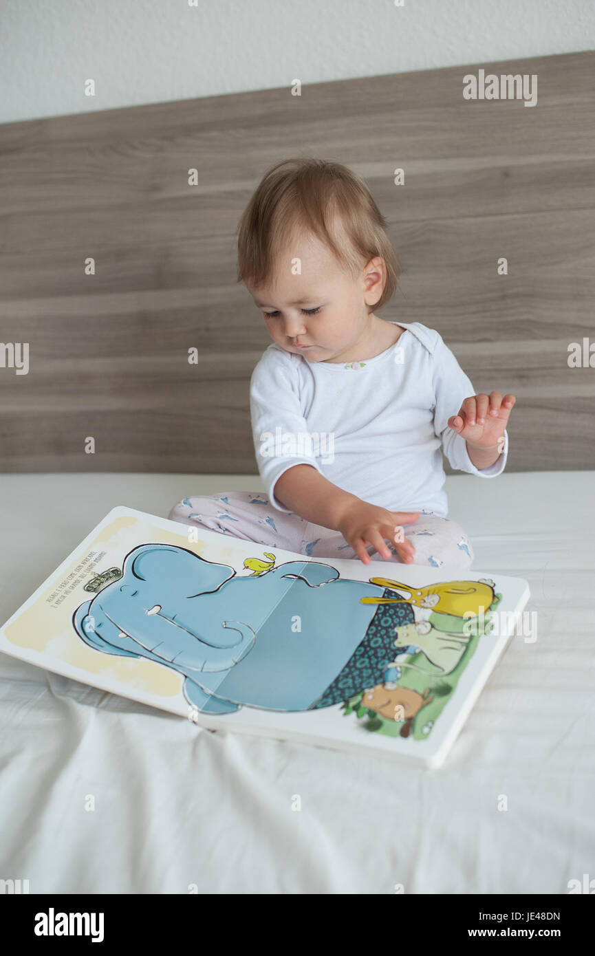 One year old infant looking at at a colorful children´s book Stock ...