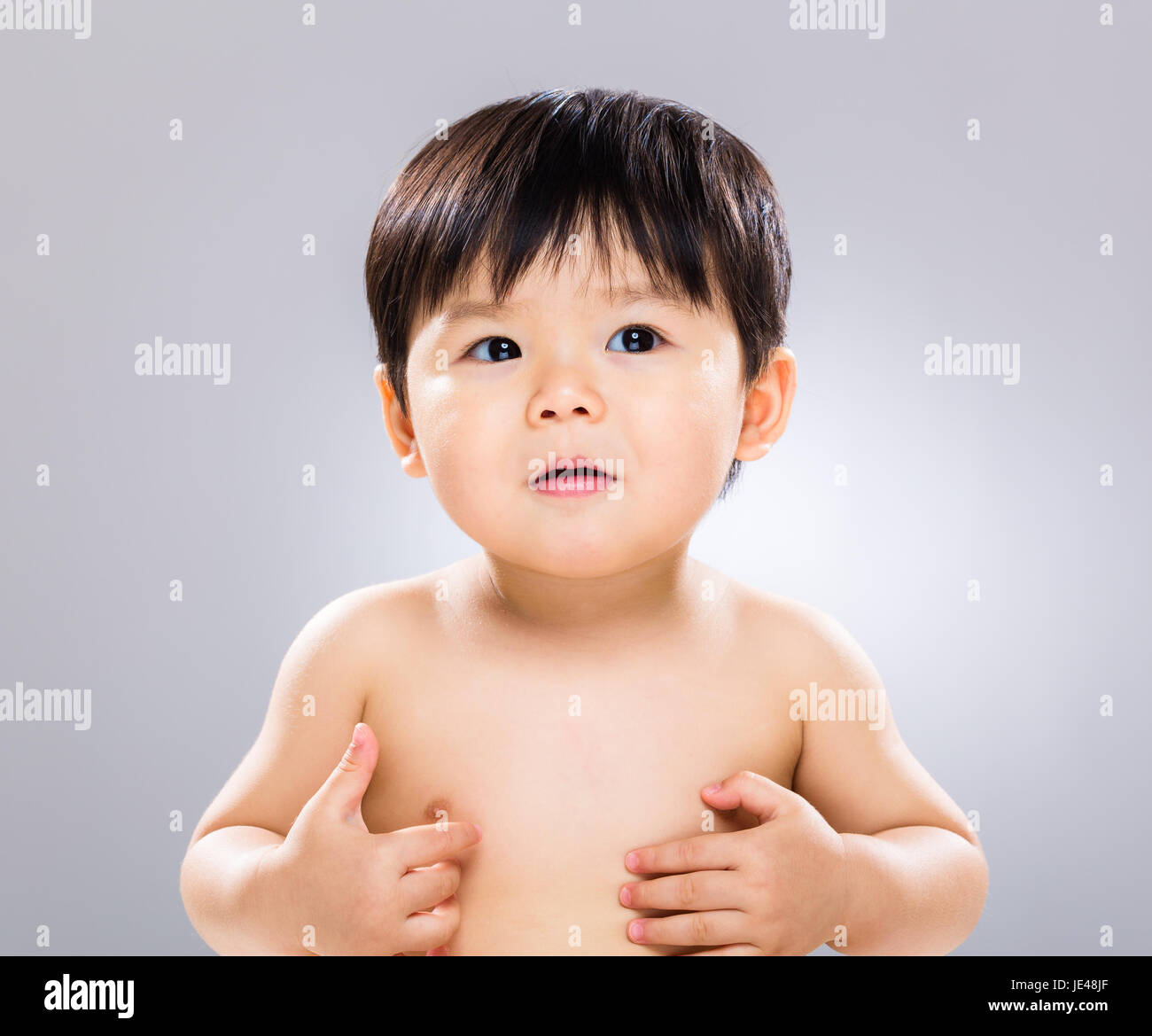 Cute baby boy scratch his body Stock Photo - Alamy