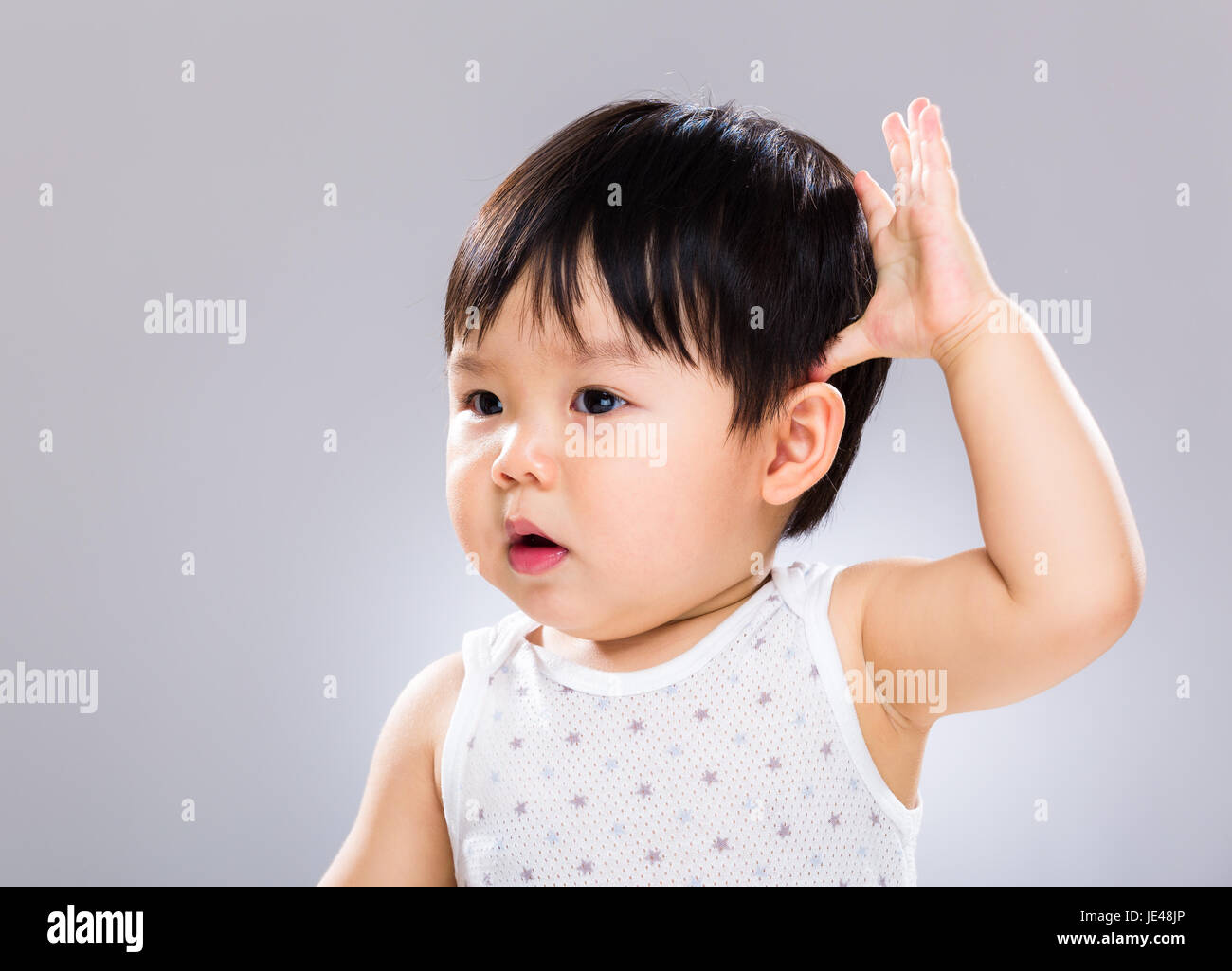Baby boy hand touch head Stock Photo - Alamy