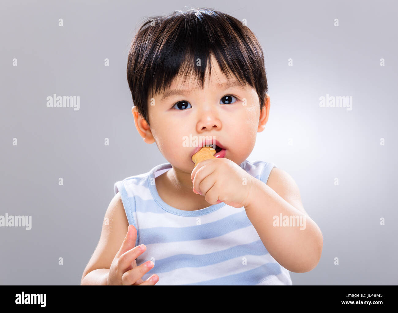 Asian boy eating snack Stock Photo - Alamy