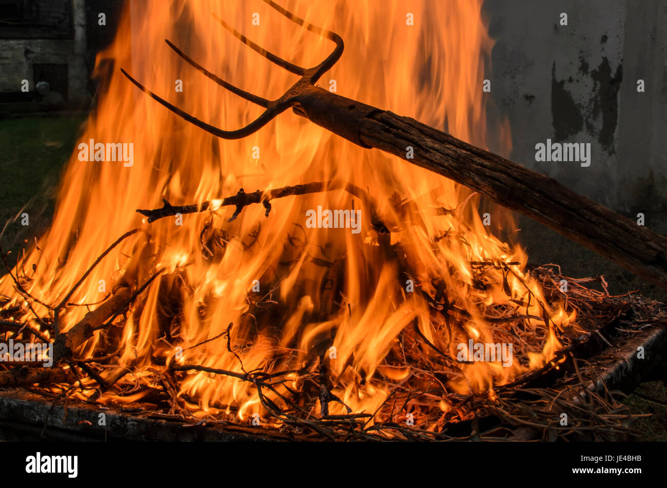 The fork moves the wood burning with high flames Stock Photo - Alamy