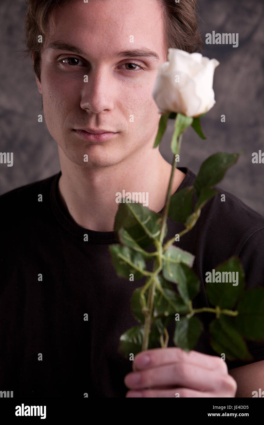 young fascinating man with a white rose looking good Stock Photo - Alamy