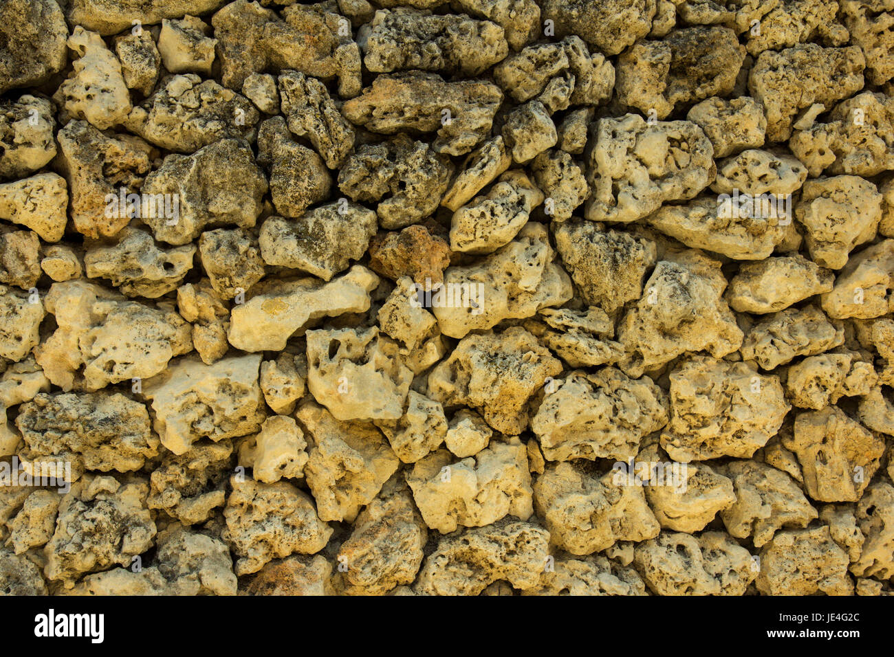 Old yellow stone wall texture background closeup Stock Photo - Alamy