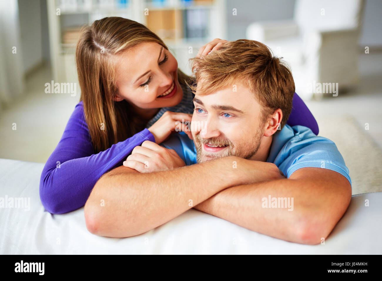 Cheerful young couple having rest at home Stock Photo - Alamy