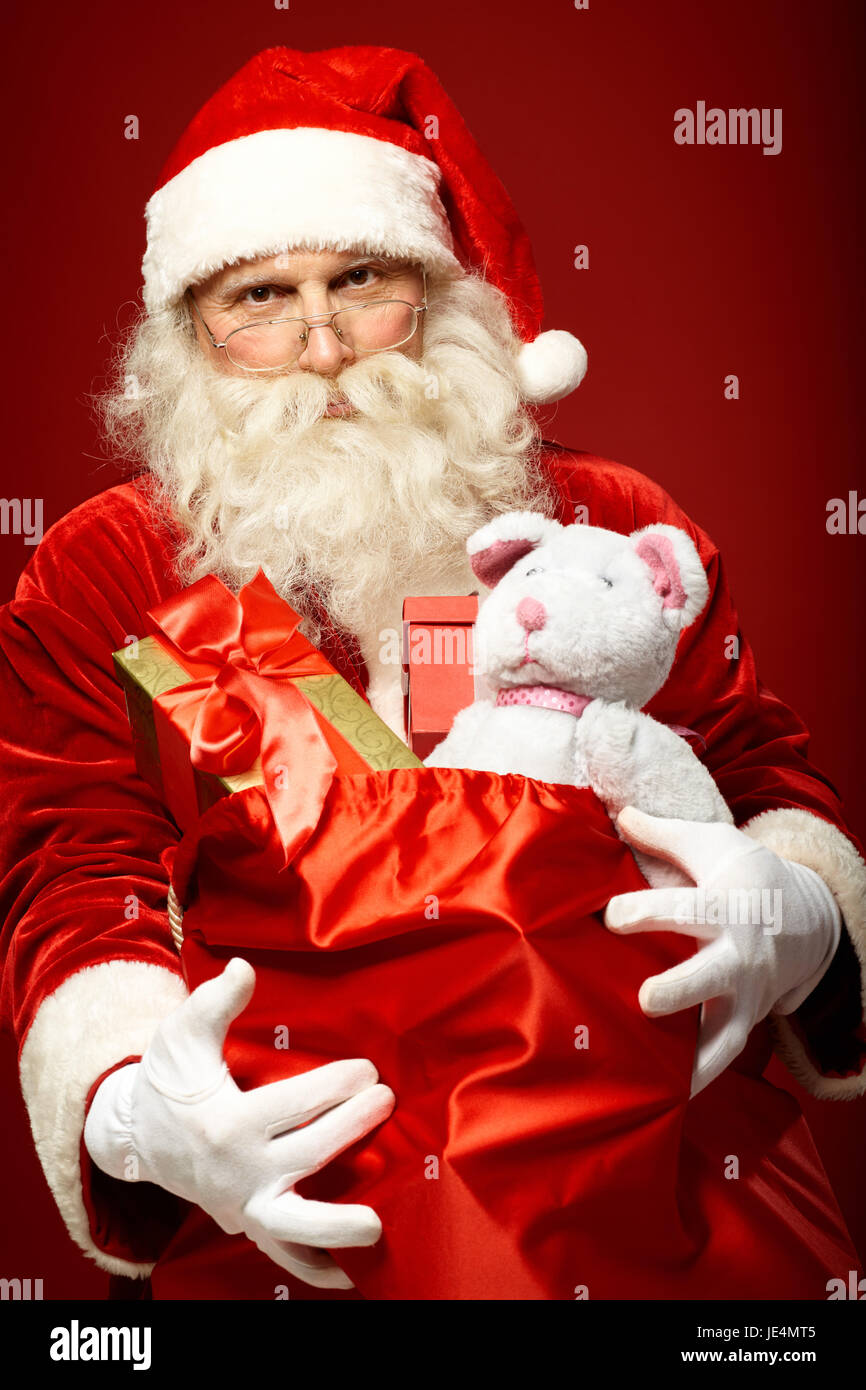 Portrait of generous Santa Claus holding presents in big red sack Stock ...