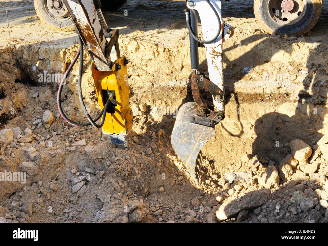 Two excavators in action to perform an excavation in rock. One with ...