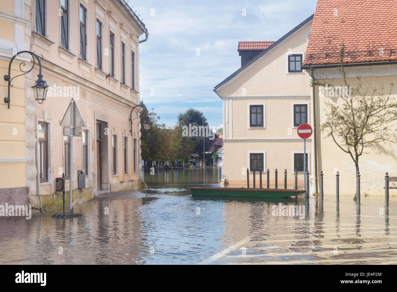 Rural village houses in floodwater. Road with the river overflown with ...