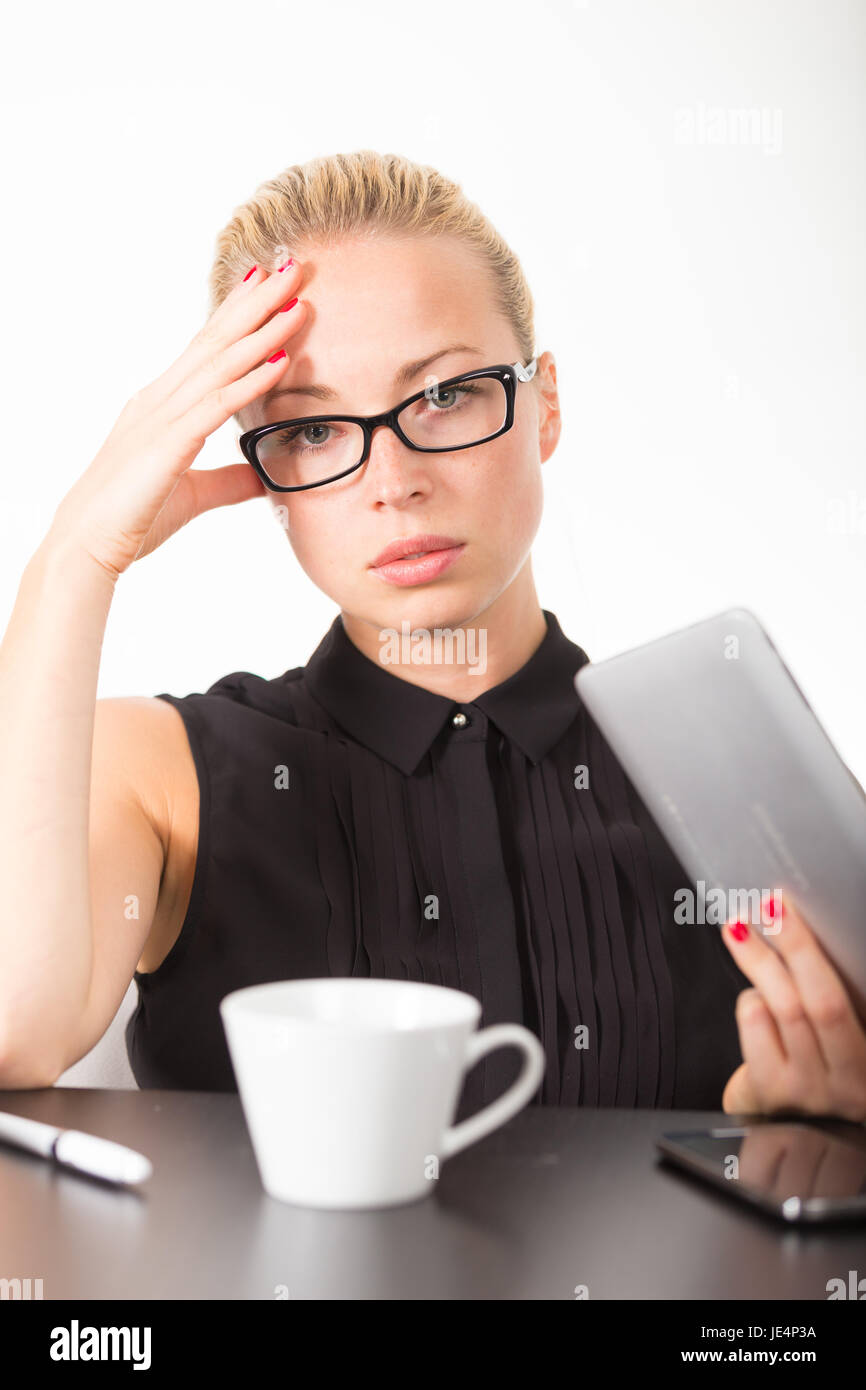 Burned out business woman in office working on her tablet PC having a ...