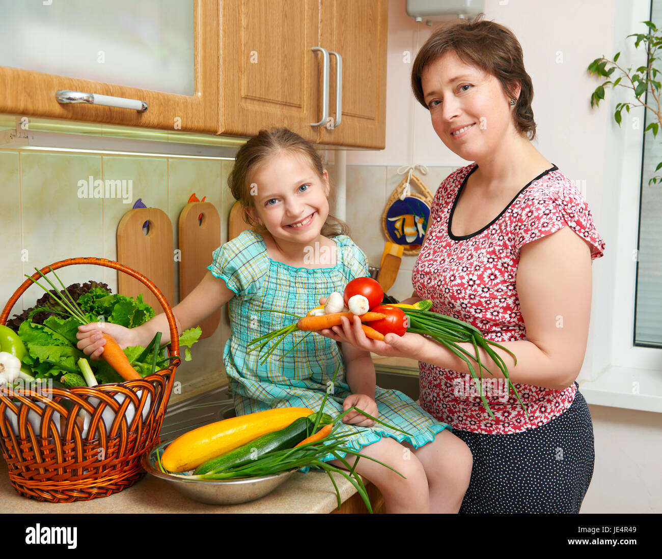 Mother and daughter with basket of vegetables and fresh fruits in ...
