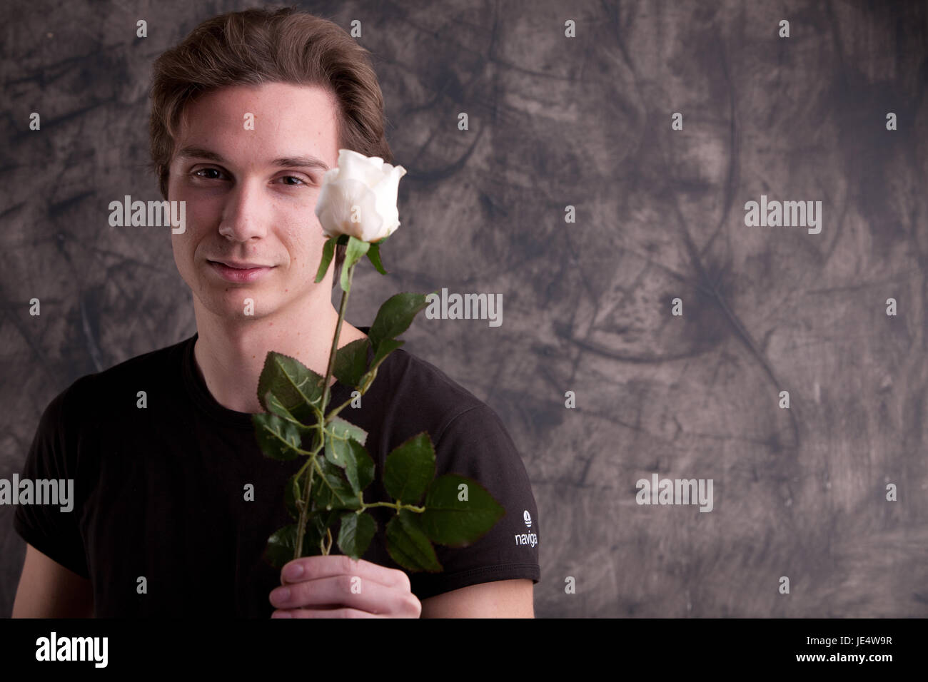 boyfriend giving a white rose to his girlfriend Stock Photo - Alamy