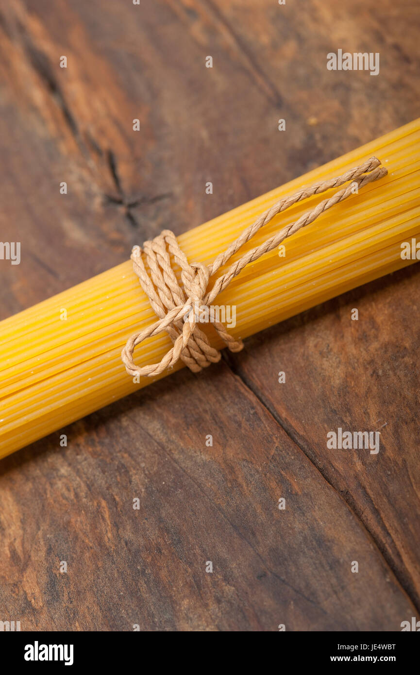 Italian pasta spaghetti tied with a rope on a rustic table Stock Photo ...