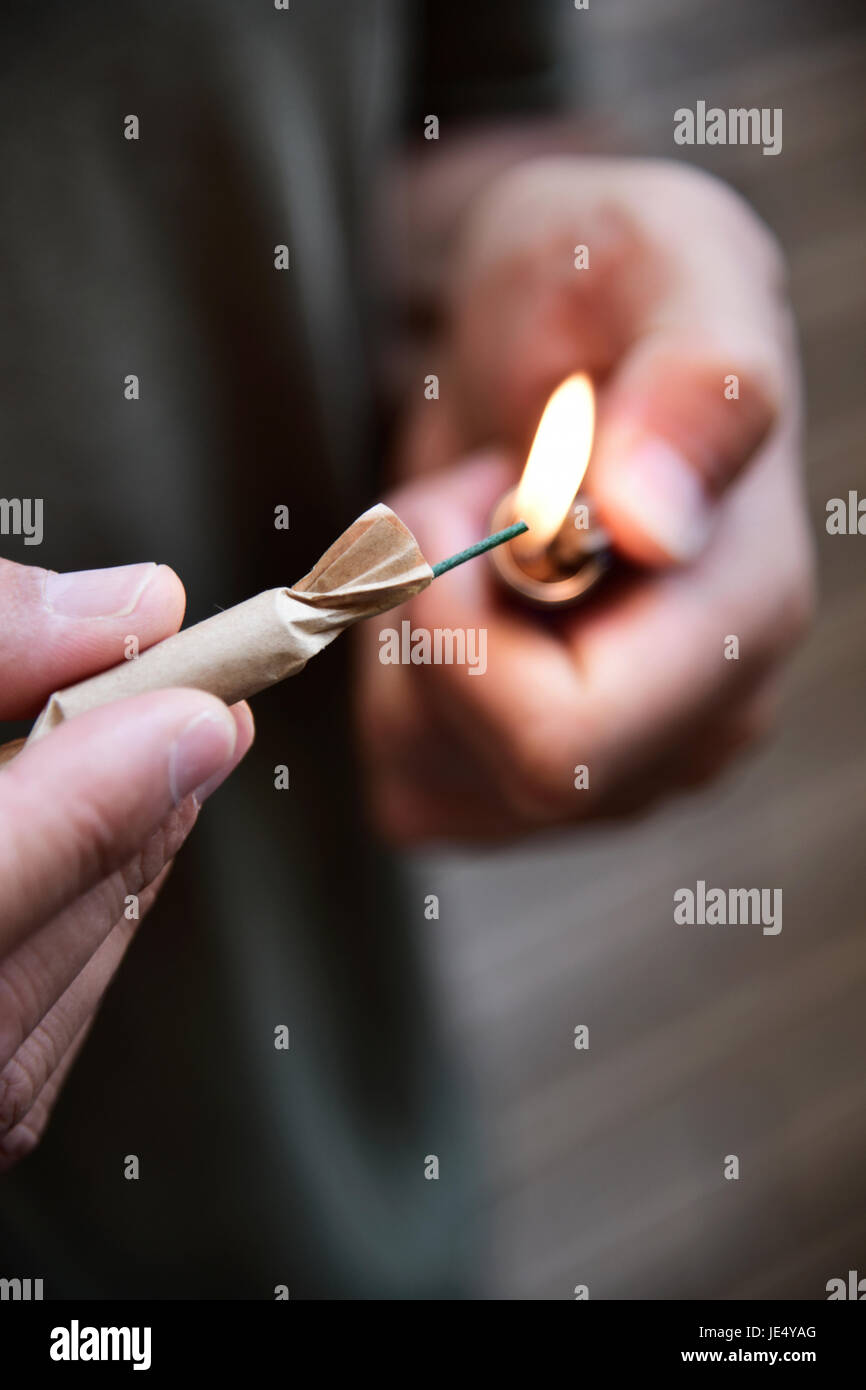 Man lighting fire cracker hi-res stock photography and images - Alamy
