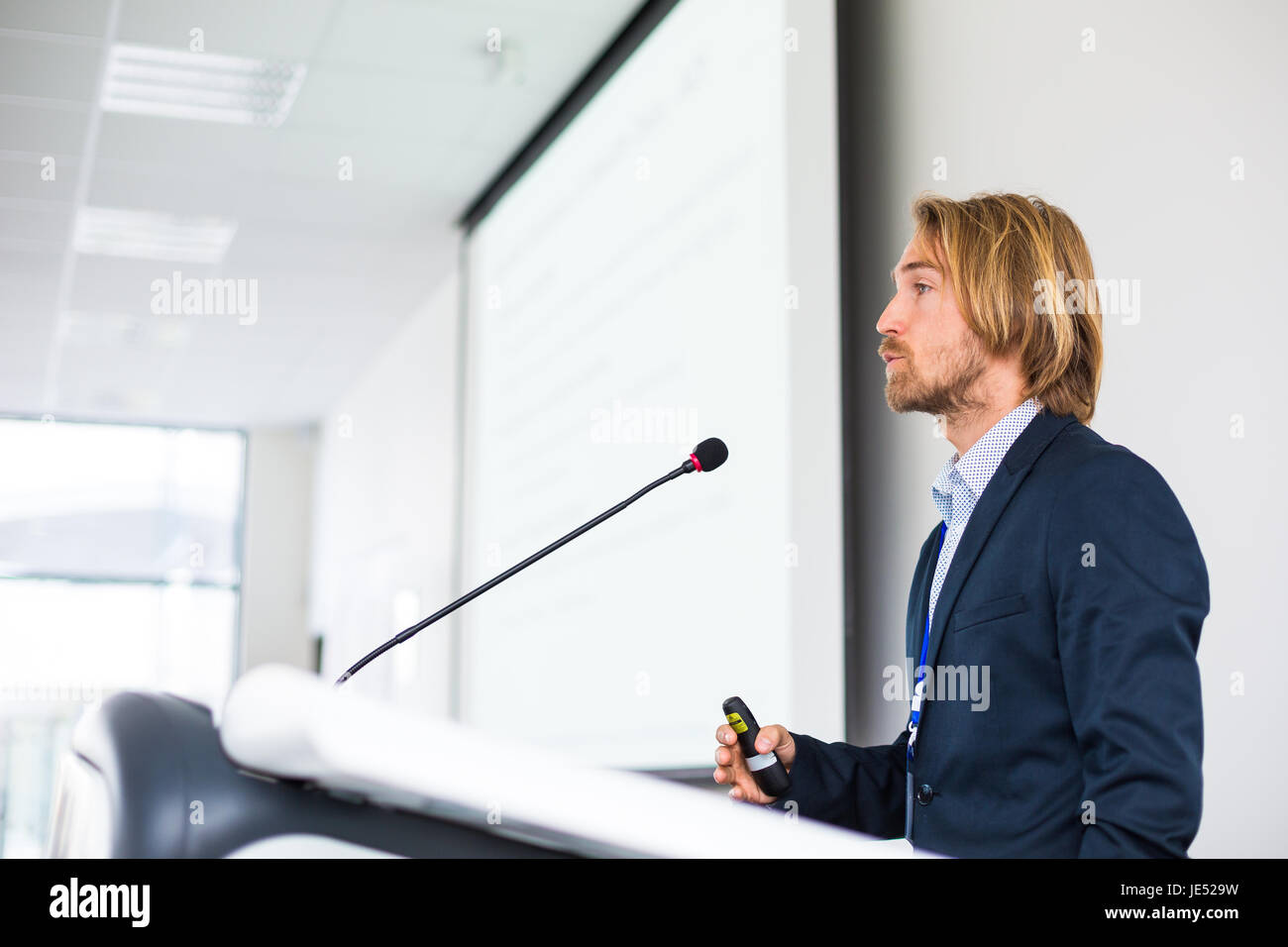 Handsome young man giving a speech at a conference Stock Photo - Alamy