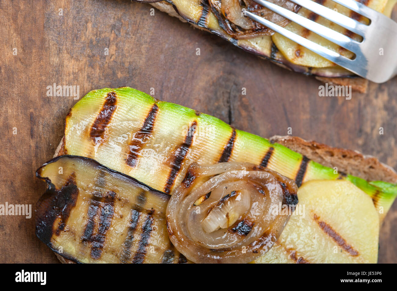 grilled vegetables on rustic bread over wood table Stock Photo - Alamy