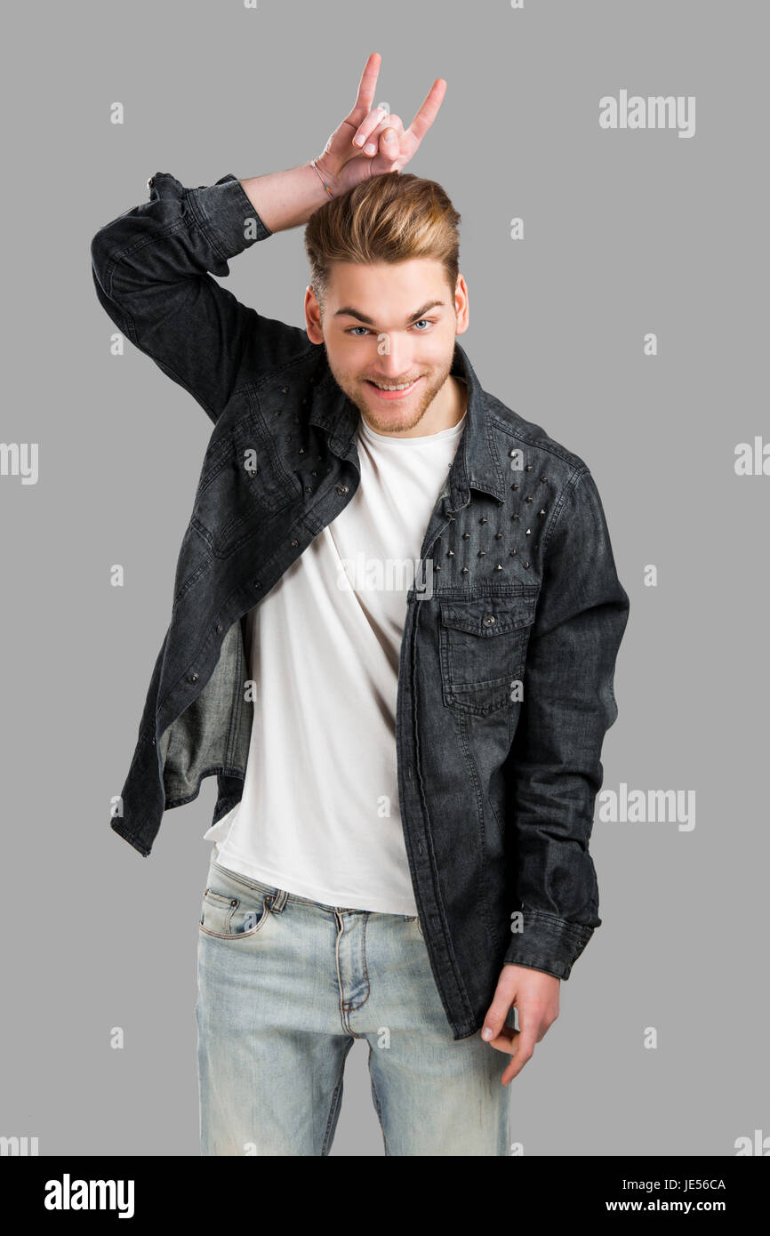 Good looking young man smiling and making a funny face, isolated over a ...