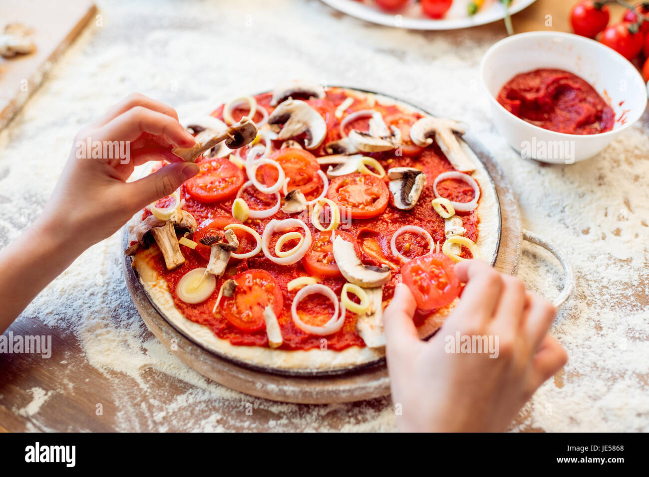 partial view of child putting ingredients while making pizza Stock ...