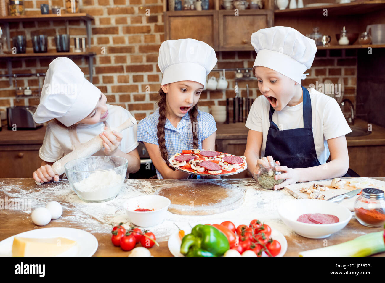 kids in chef hats making pizza together Stock Photo - Alamy
