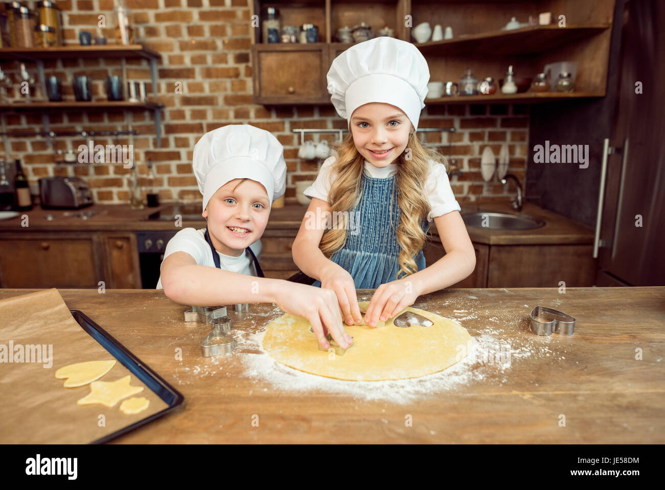 little kids in chef hats making shaped cookies in kitchen Stock Photo ...