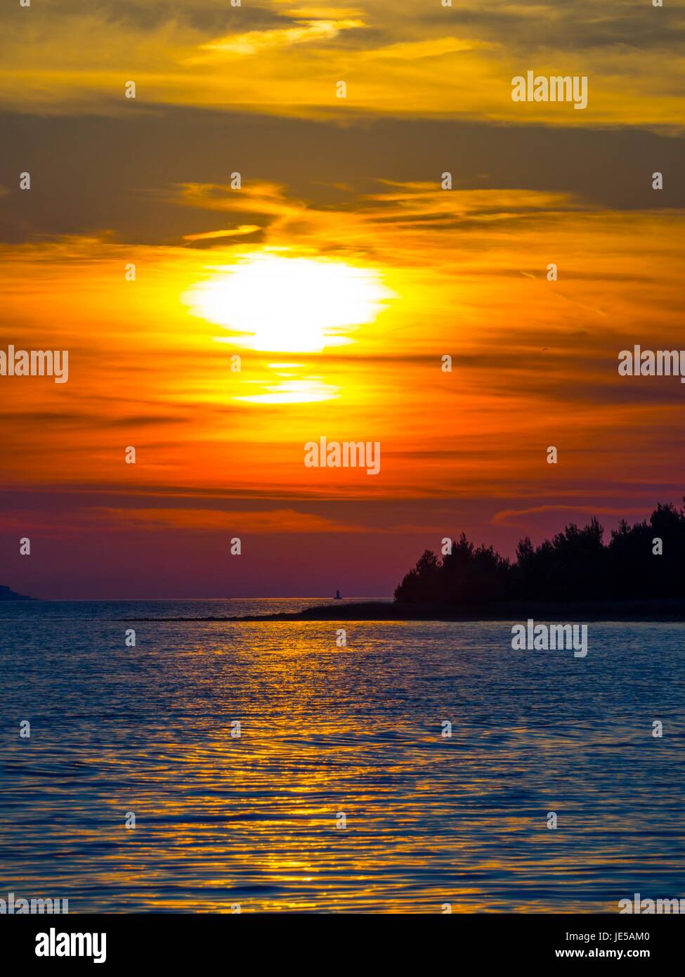 Setting sun behind an island in silhouette hi-res stock photography and ...