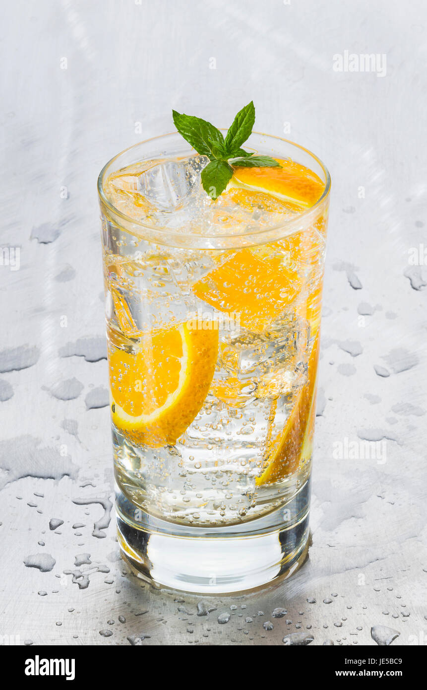 Glass of refreshing cold mineral water with pieces of orange Stock ...
