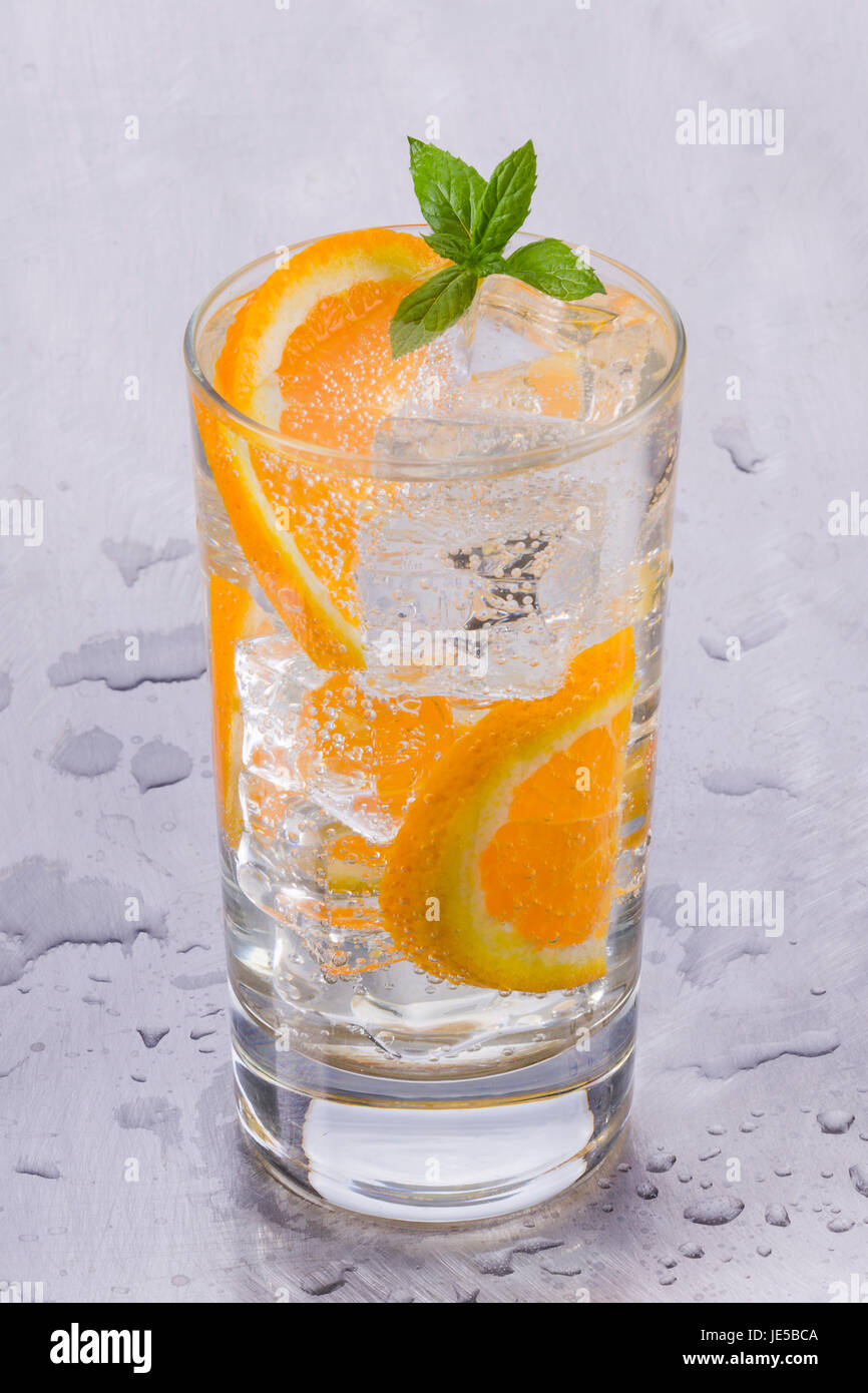 Glass of refreshing cold mineral water with pieces of orange Stock ...
