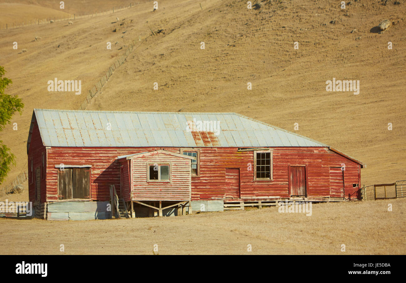Red paint shearing shed against very dry hillside Stock Photo - Alamy