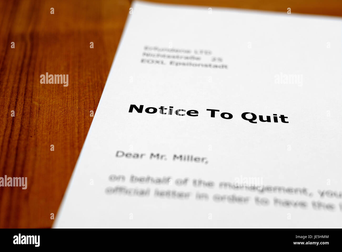 A letter on a wooden table - notice to quit Stock Photo - Alamy