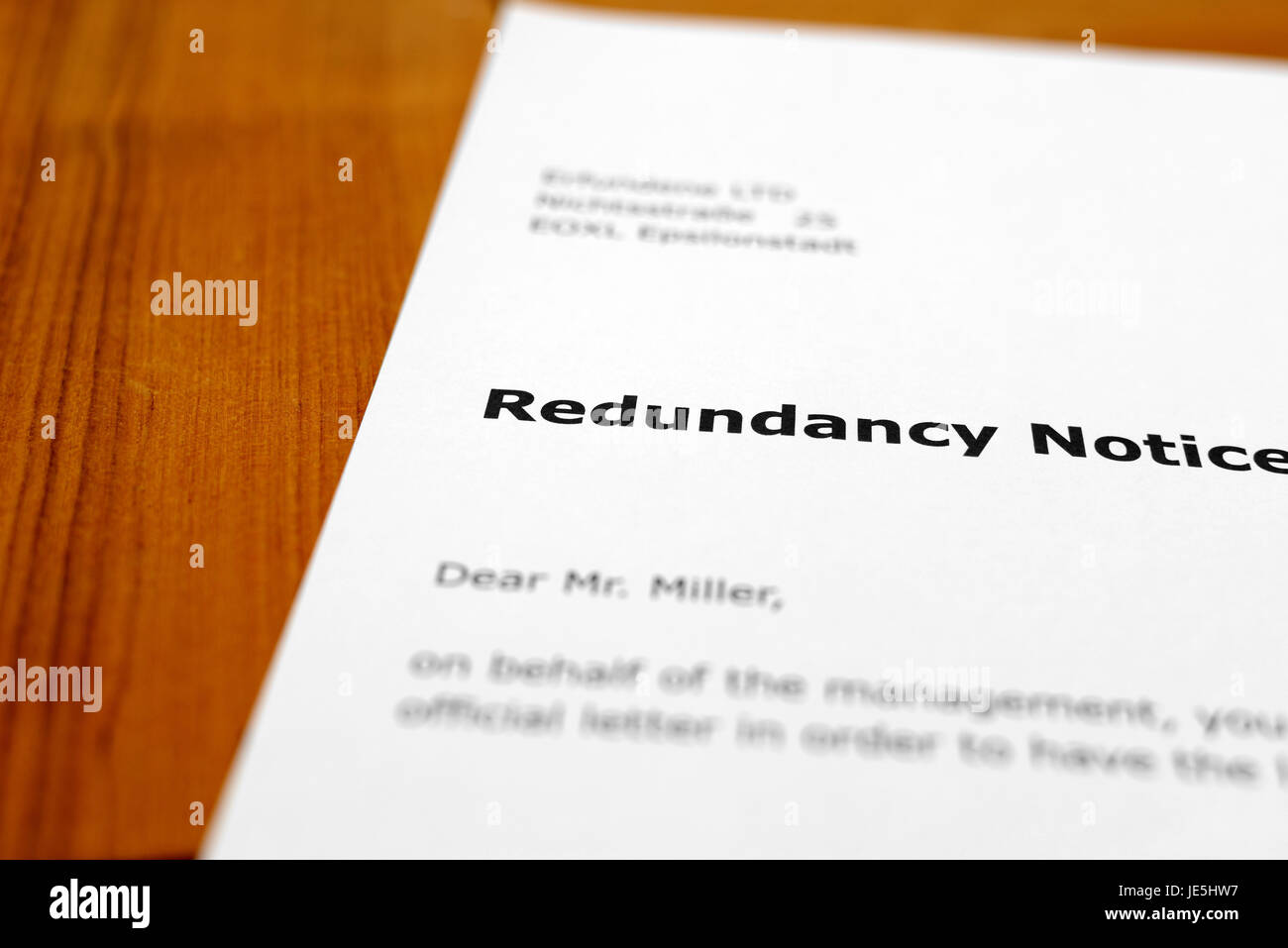 A letter on a wooden table - redundancy notice Stock Photo - Alamy