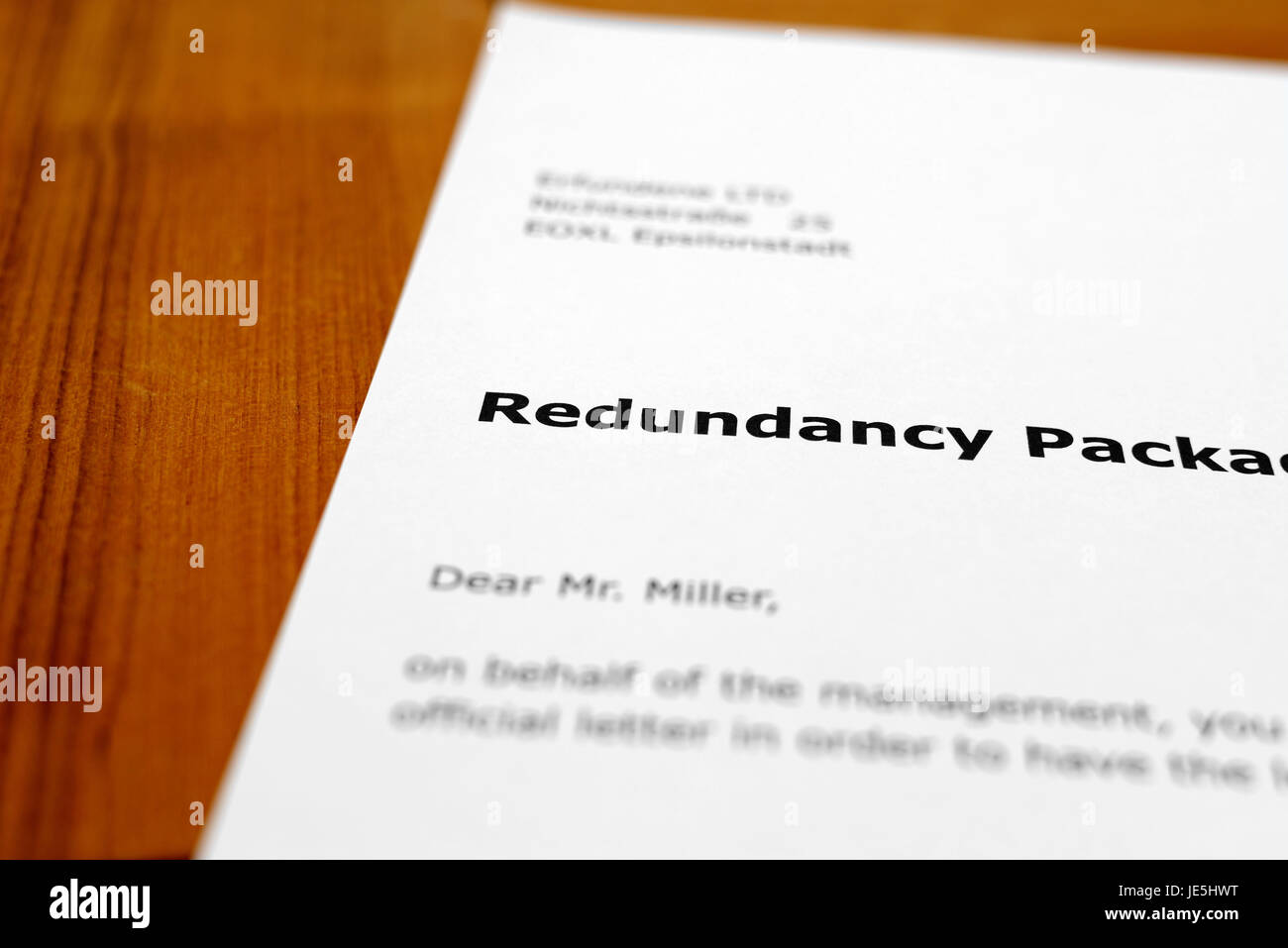 A letter on a wooden table - redundancy package Stock Photo - Alamy