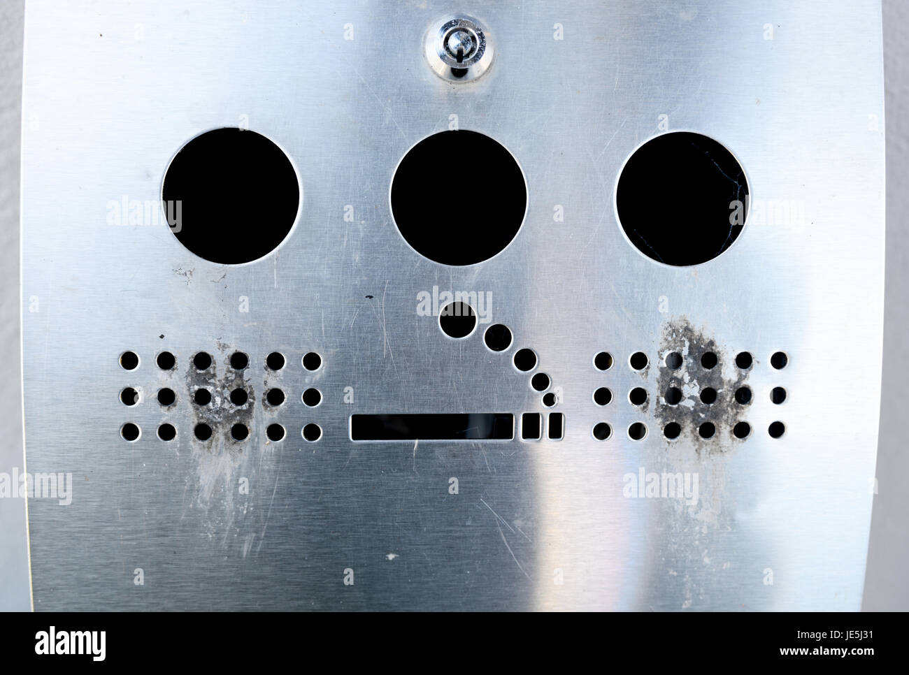 Wall mounted outdoor ashtray showing signs of use Stock Photo - Alamy