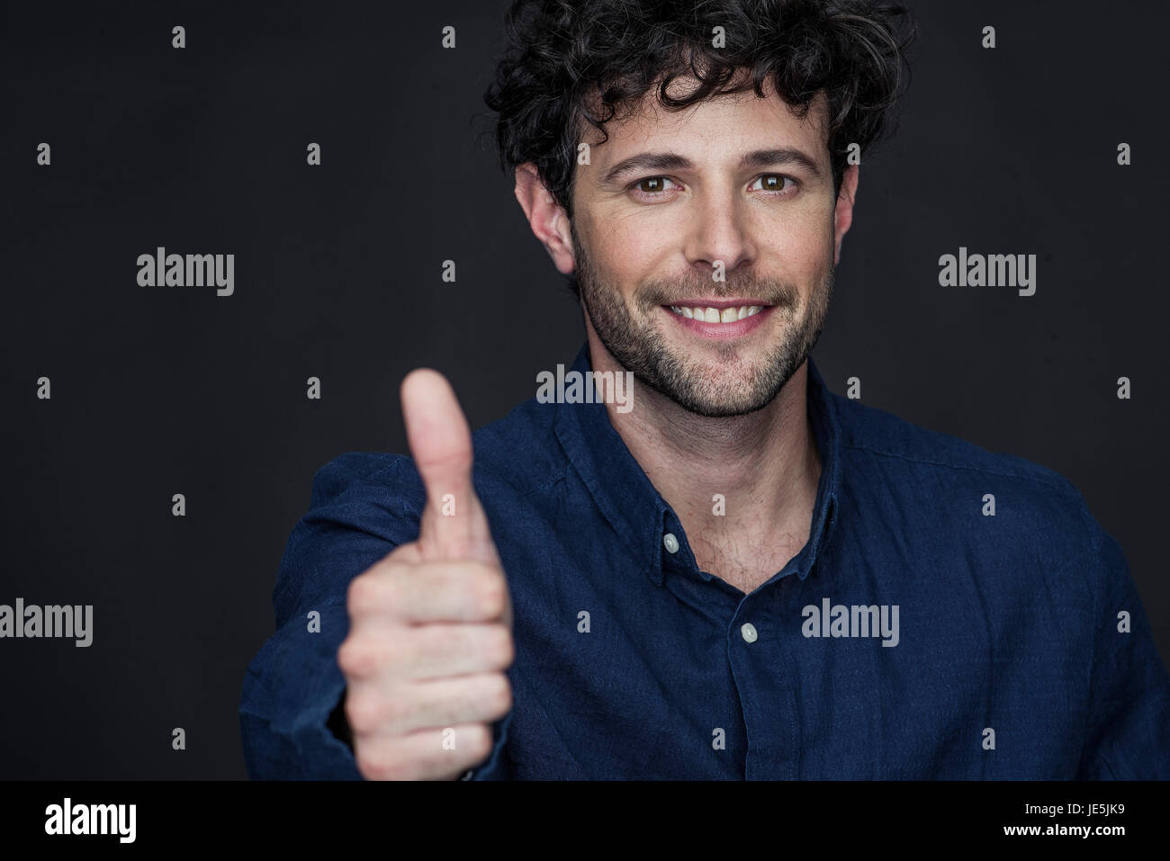 Man giving thumbs up and smiling, portrait Stock Photo - Alamy