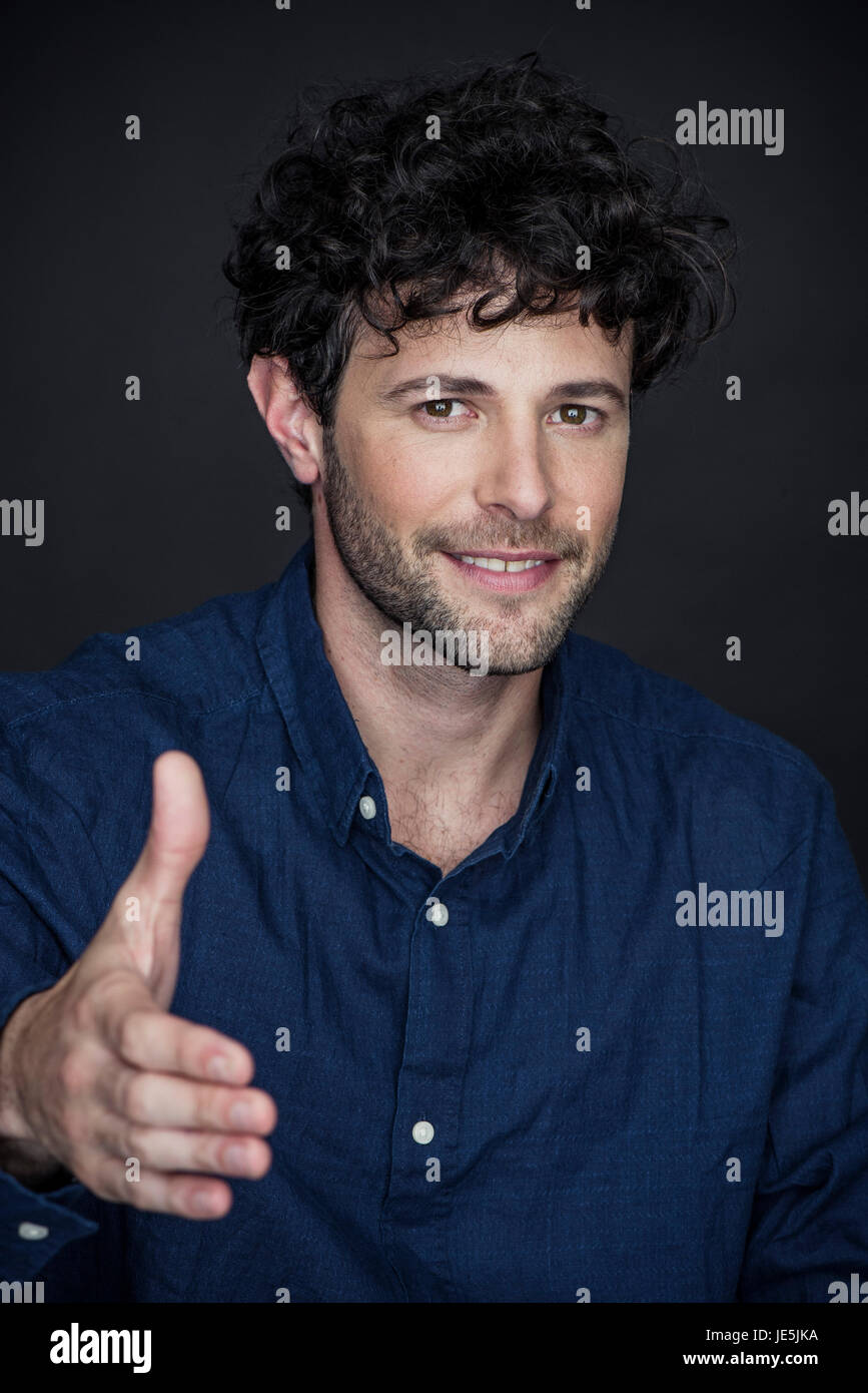 Man holding out hand and smiling, portrait Stock Photo - Alamy