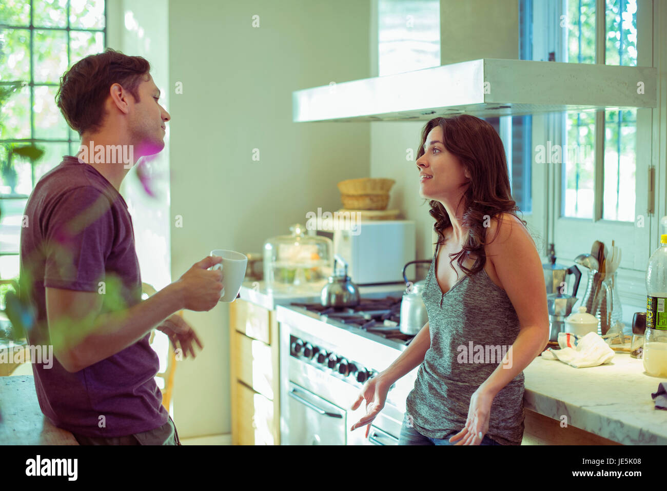 Couple talking in kitchen Stock Photo - Alamy