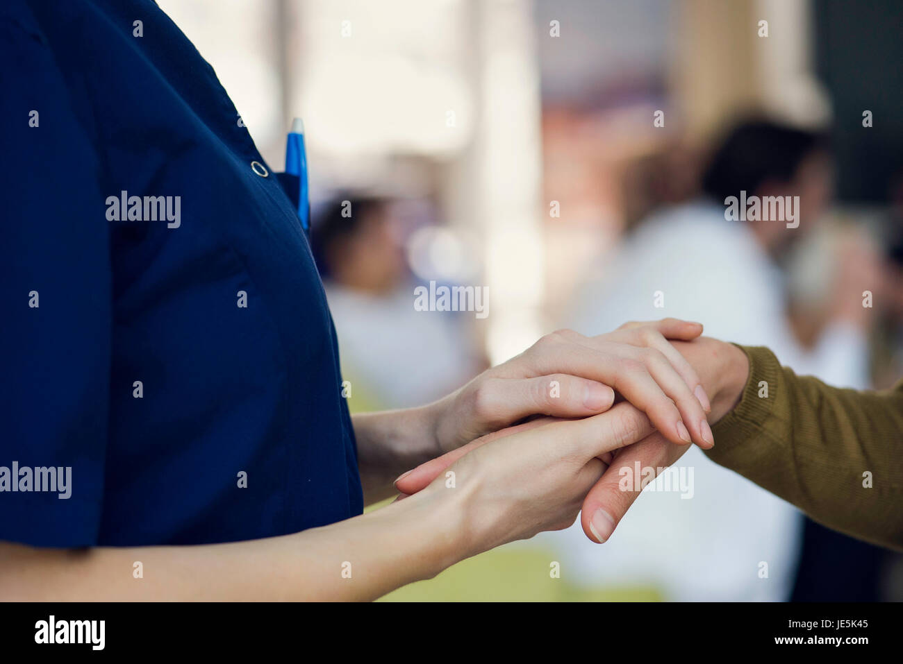 Healthcare worker holding patient's hand Stock Photo - Alamy