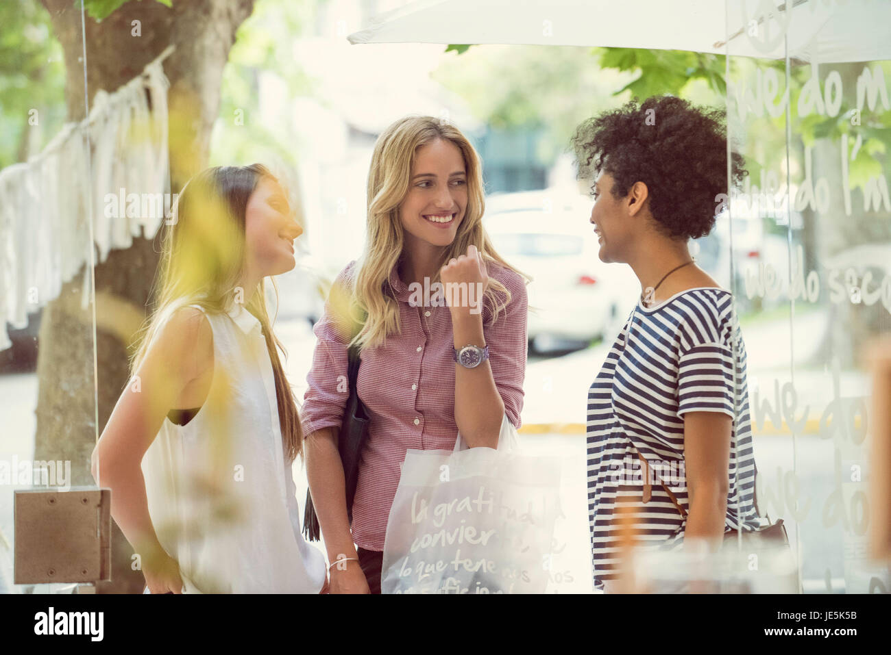Friends chatting together while shopping Stock Photo - Alamy