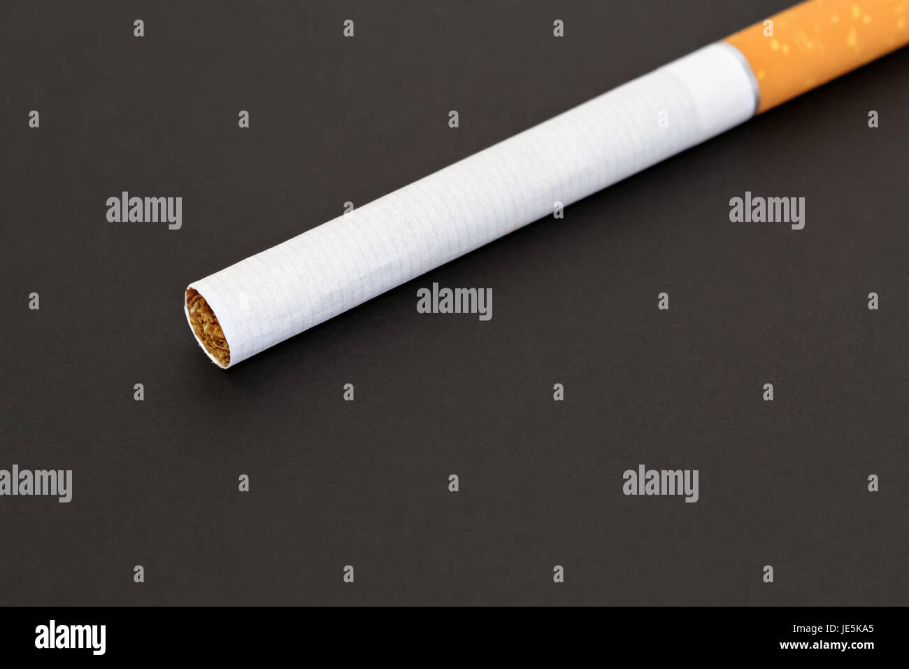 Closeup of a cigarette on dark background Stock Photo - Alamy
