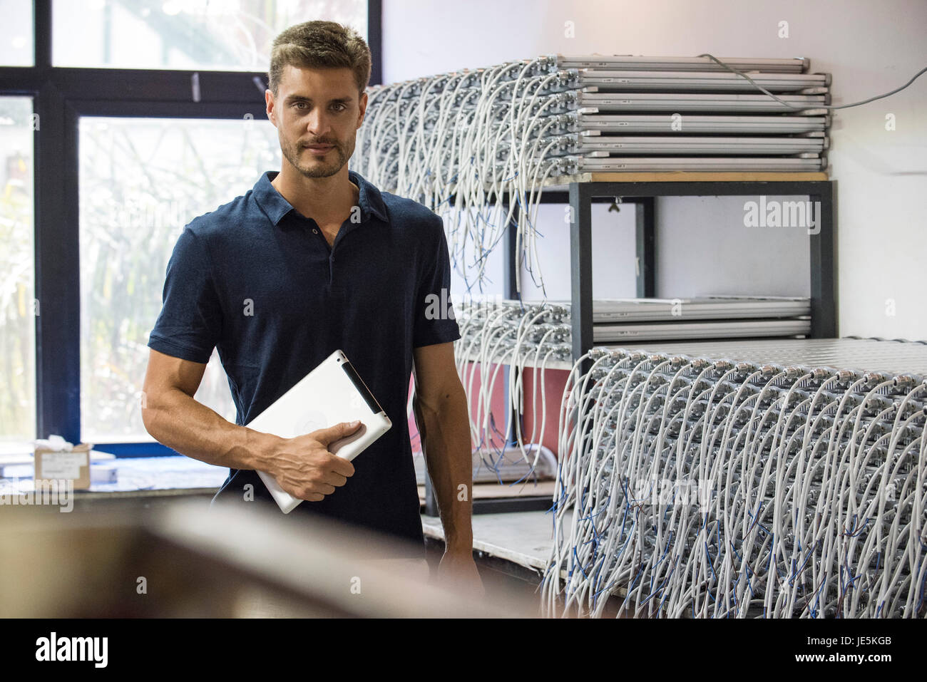 Factory worker holding digital tablet, portrait Stock Photo - Alamy