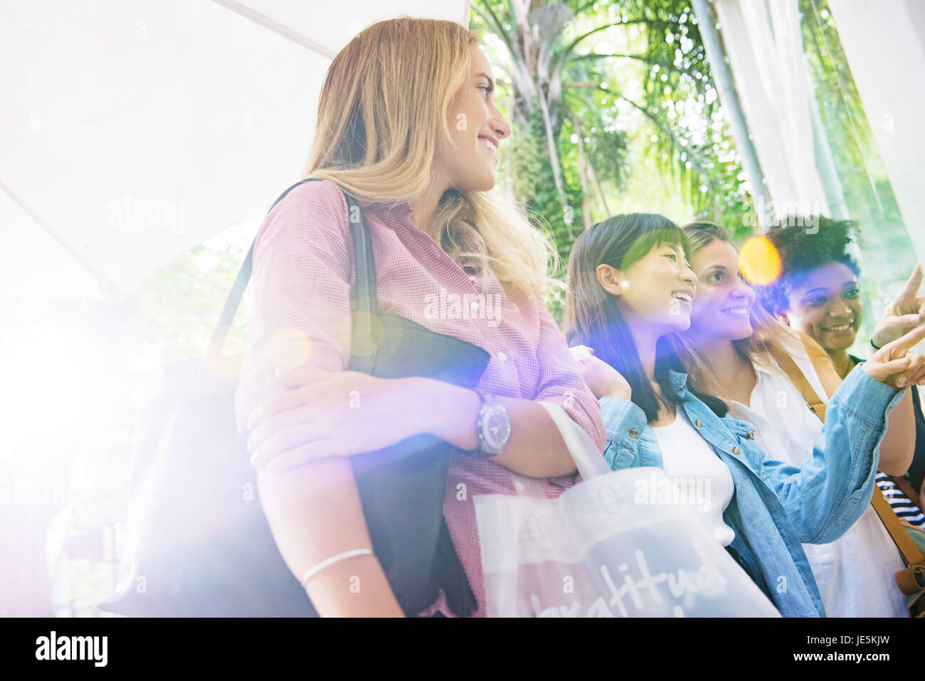 Friends looking through shop window together Stock Photo - Alamy