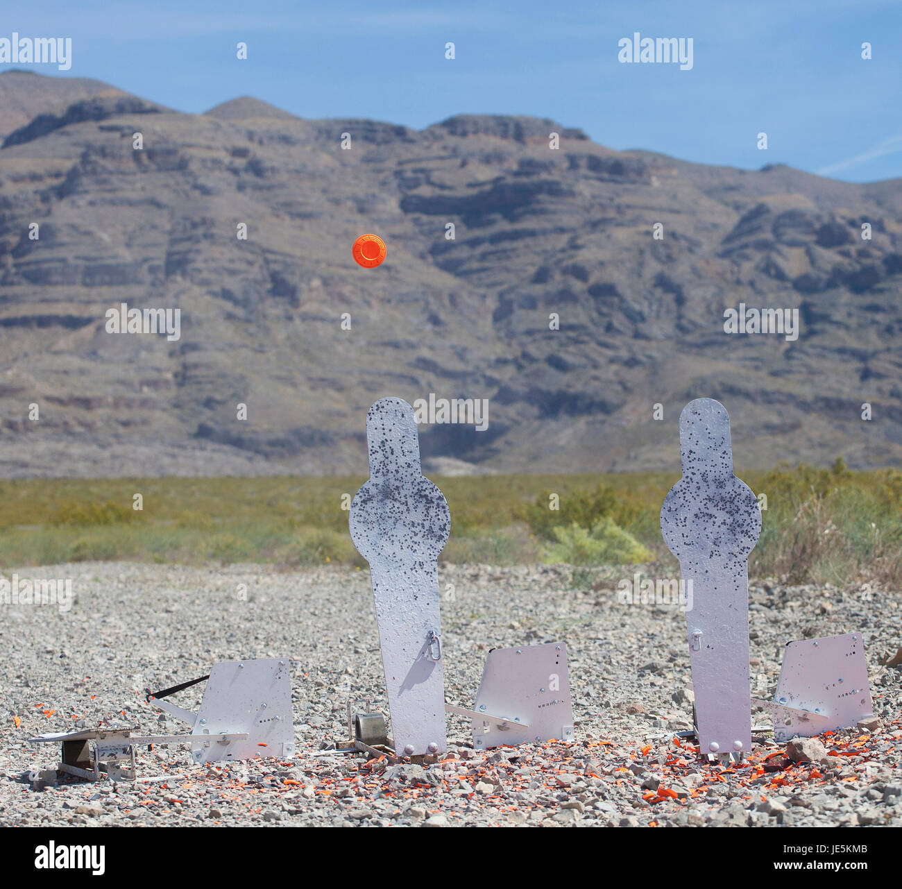 Orange clay target flying from behind a steel shooting target Stock ...