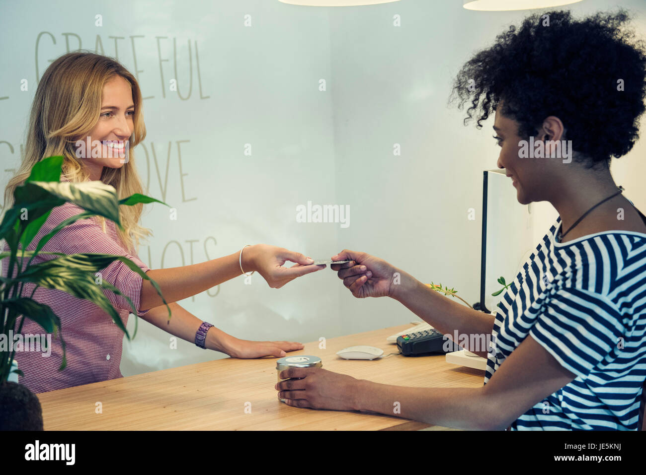Shopper using credit card to make purchase in shop Stock Photo - Alamy